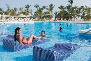 Uma área de piscina com espreguiçadeiras e palmeiras.
