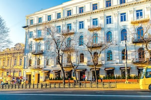 Um edifício de vários andares com estilo arquitetônico clássico, com janelas em arco e sacadas.