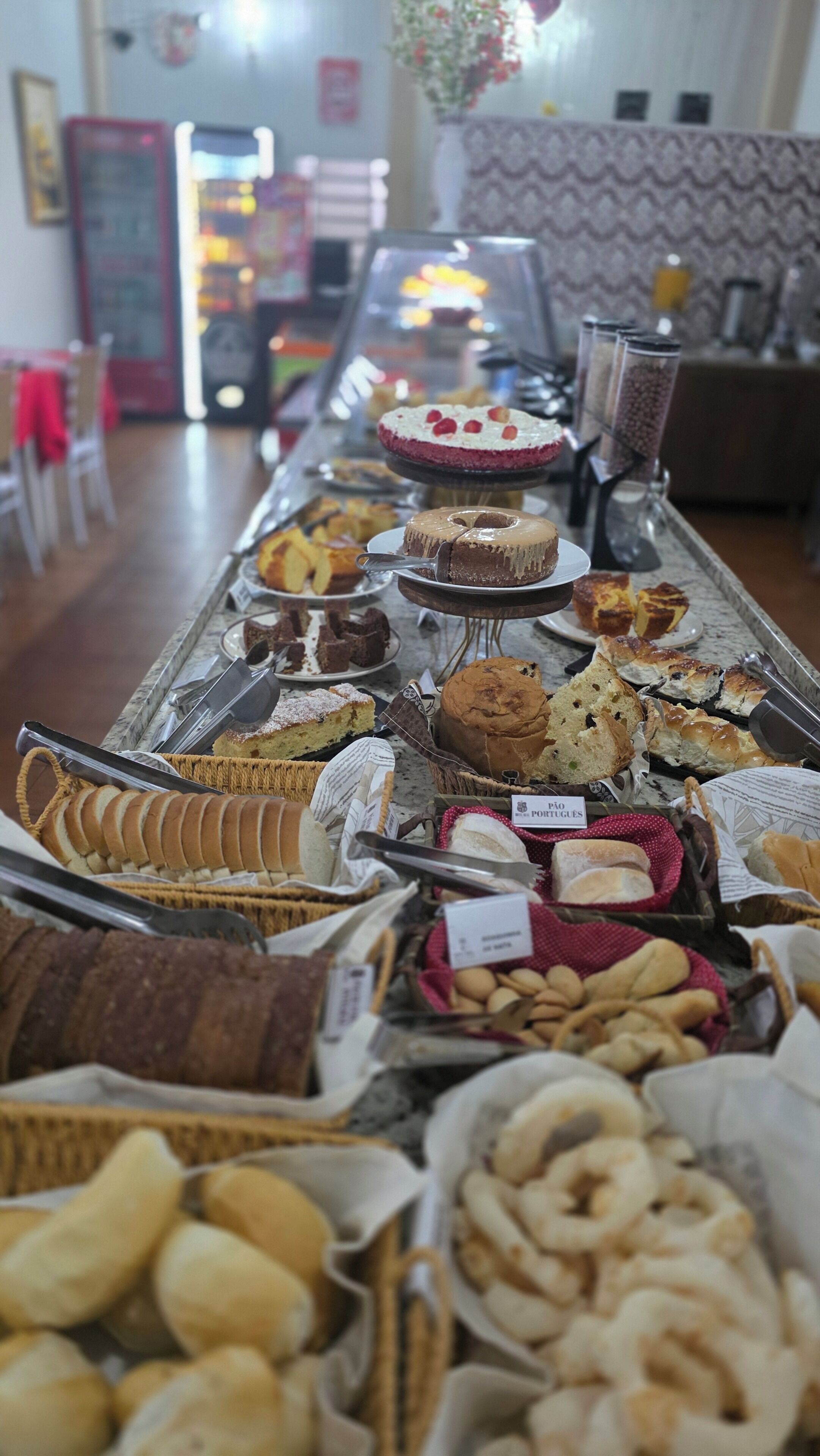 Um buffet com diversos pães e doces.