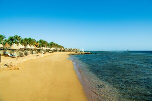 Uma praia privada, espreguiçadeiras, guarda-sóis de praia 