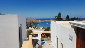 Vista de uma área costeira com edifícios, uma escadaria e um céu azul claro.