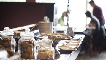 Buffet montado com diversos alimentos e utensílios de servir.