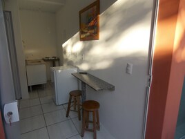 Um frigorífico, uma placa de cozinha, utensílios de cozinha 