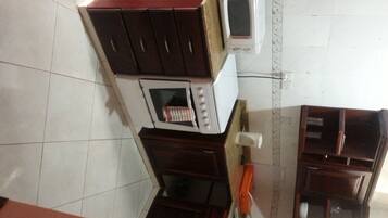 Uma cozinha com micro-ondas, forno e armários.