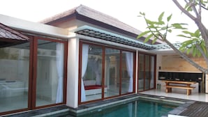 Uma casa moderna com piscina, amplas janelas de vidro e deck de madeira.