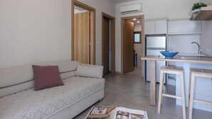Apartamento moderno com sala de estar, cozinha compacta e área de jantar.