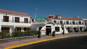 Um edifício com uma placa indicando 'Grinanesa Restaurant' e várias bandeiras.