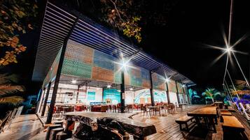 Um restaurante com área externa, um deck de madeira e design arquitetônico moderno.