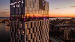Hotel Clarion Helsinki com design moderno, grandes janelas e vista para a paisagem urbana e para a água.