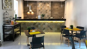 Um restaurante moderno com balcão, cadeiras e uma parede decorativa.