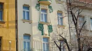 Um edifício de vários andares com varandas ornamentadas e uma placa com a inscrição 'MERA HOTEL'.