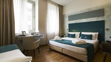 Quarto de hotel com cama, escrivaninha, cadeira e vista para o exterior.