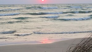 Uma praia com ondas e um pôr do sol.