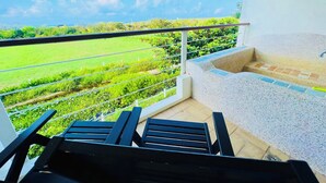 Uma varanda com vista para um campo verde e um banco de pedra.