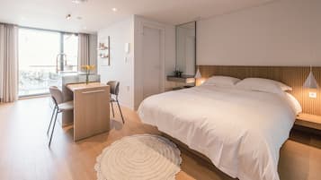Um quarto moderno com uma cama grande, uma escrivaninha e uma cadeira.