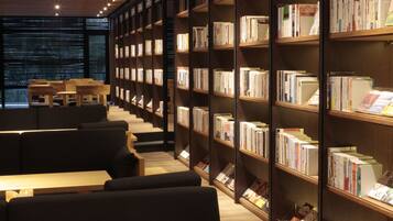Uma biblioteca com estantes, assentos e uma escadaria.