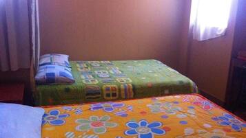 Quarto com duas camas, cada uma com colcha colorida.