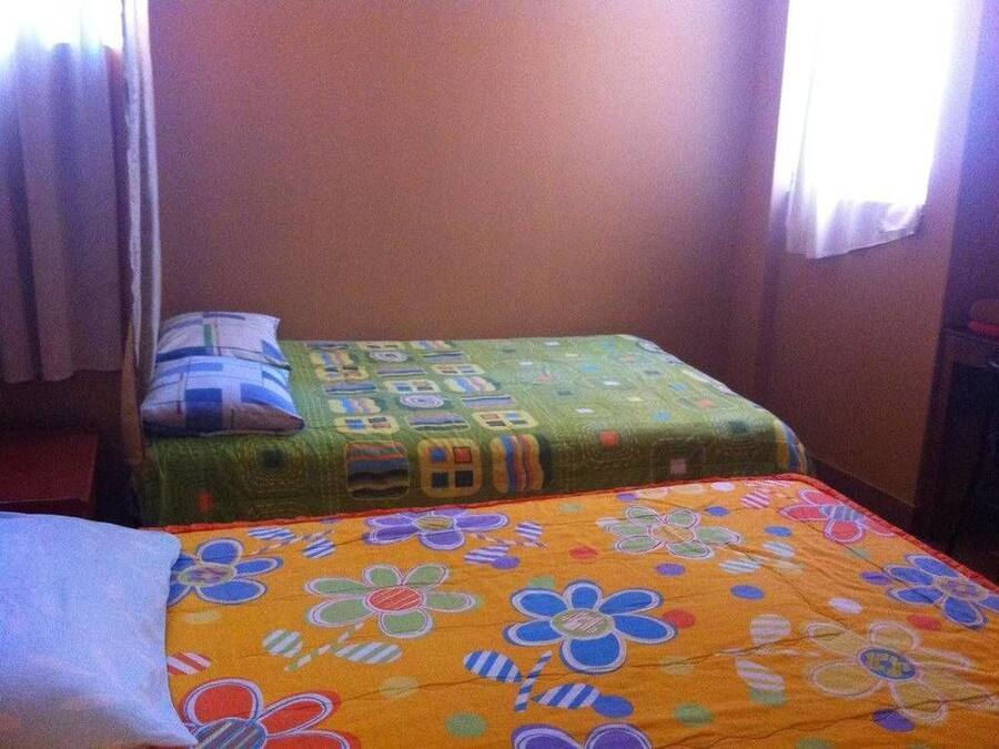 Quarto com duas camas, cada uma com colcha colorida.
