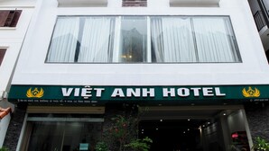 Um hotel com vários andares, com uma placa indicando 'VIET ANH HOTEL' e um logotipo acima da entrada.
