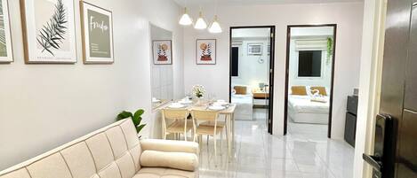 Uma sala de estar moderna com sofá, área de jantar e cozinha.