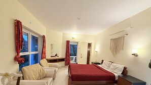 Quarto com cama, cadeira, penteadeira, escrivaninha e espelho.