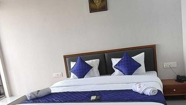 Quarto com cama, ventoinha no teto, obra de arte na parede e mesa de cabeceira.