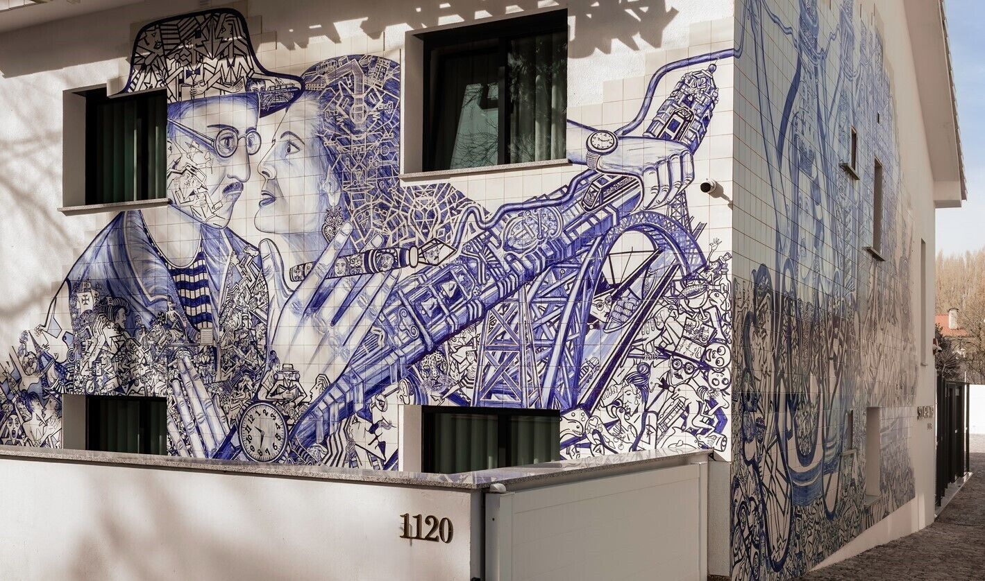 Um edifício com um grande mural com desenhos elaborados e um relógio.
