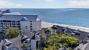 Hotel à beira-mar com vários edifícios, vista para a praia e céu limpo.