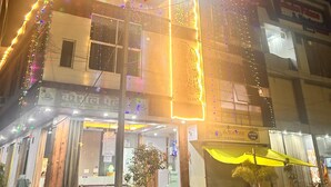 Um edifício com vários andares, iluminado por luzes de Natal, e uma placa com texto vermelho.