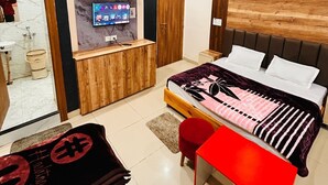 Quarto moderno com cama, televisão, guarda-roupa de madeira e ventoinha no teto.