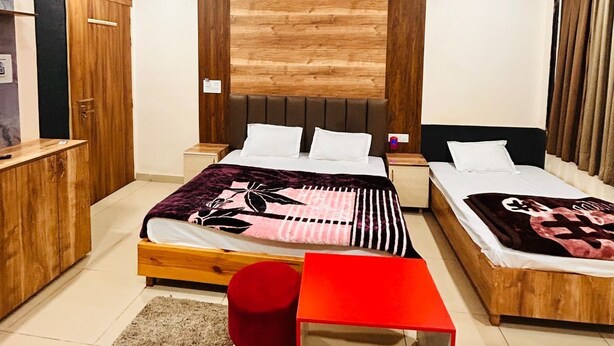 Quarto com cama, escrivaninha, cadeira, mesa, ventoinha no teto e luminária na parede.