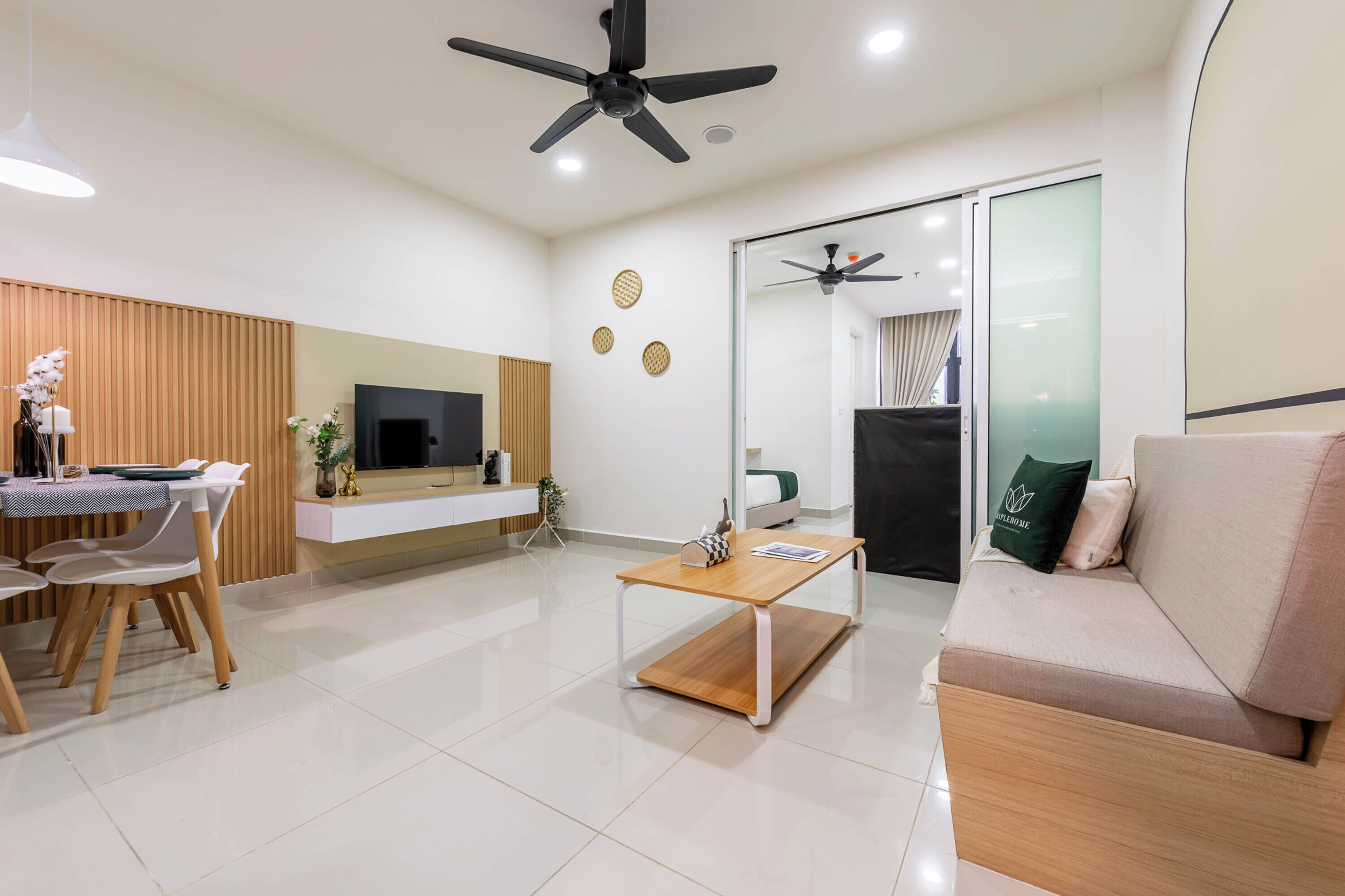 Uma sala de estar moderna com sofá, mesa de centro, TV e ventilador de teto.