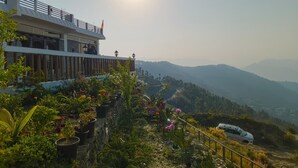 Um edifício moderno com varanda e vista para uma paisagem montanhosa.