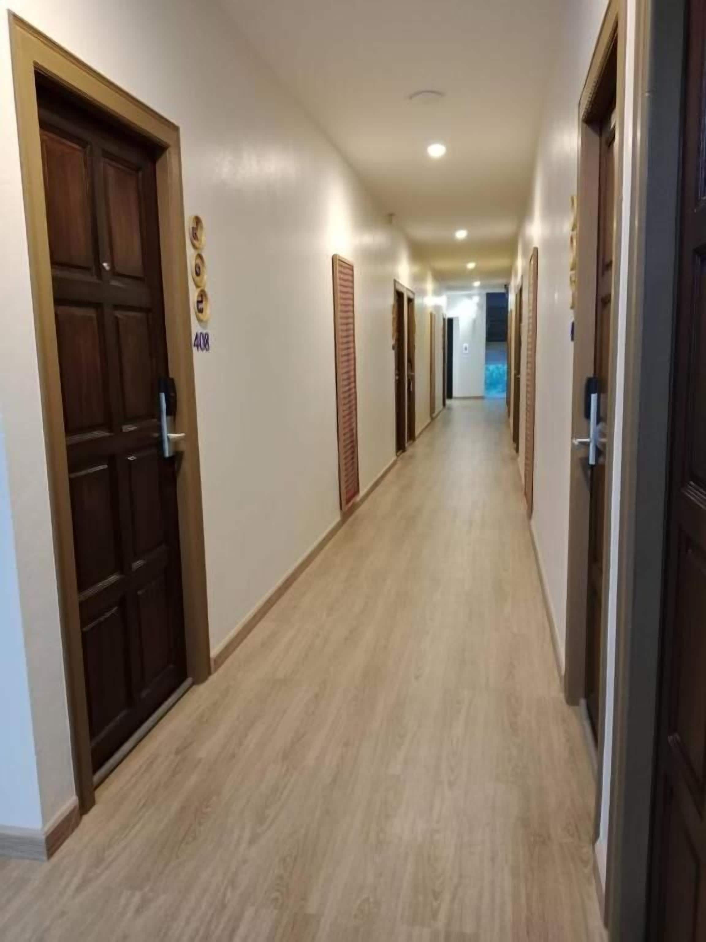 Corredor de hotel com portas de madeira, piso de cor clara e uma placa indicando a sala número 403.