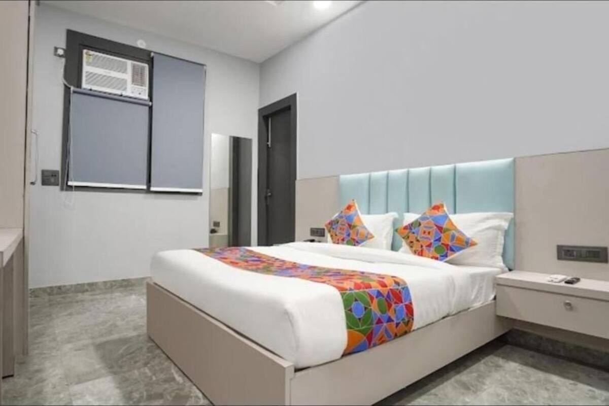 Quarto moderno com cama, mesas de cabeceira, guarda-roupa e ar condicionado.