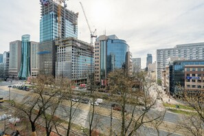 Paisagem urbana com edifícios modernos, incluindo um canteiro de obras e um edifício redondo com fachada azul.