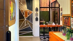 Interior moderno com teto de madeira, balcão de recepção e vista para o exterior.