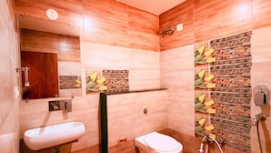 Casa de banho com lavatório, sanita e chuveiro.