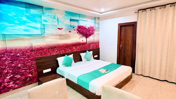 Quarto de hotel com uma cama, uma escrivaninha e uma cadeira.