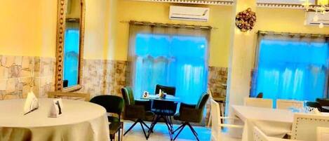 Uma área de refeições com uma mesa redonda, cadeiras e uma placa de número na mesa.