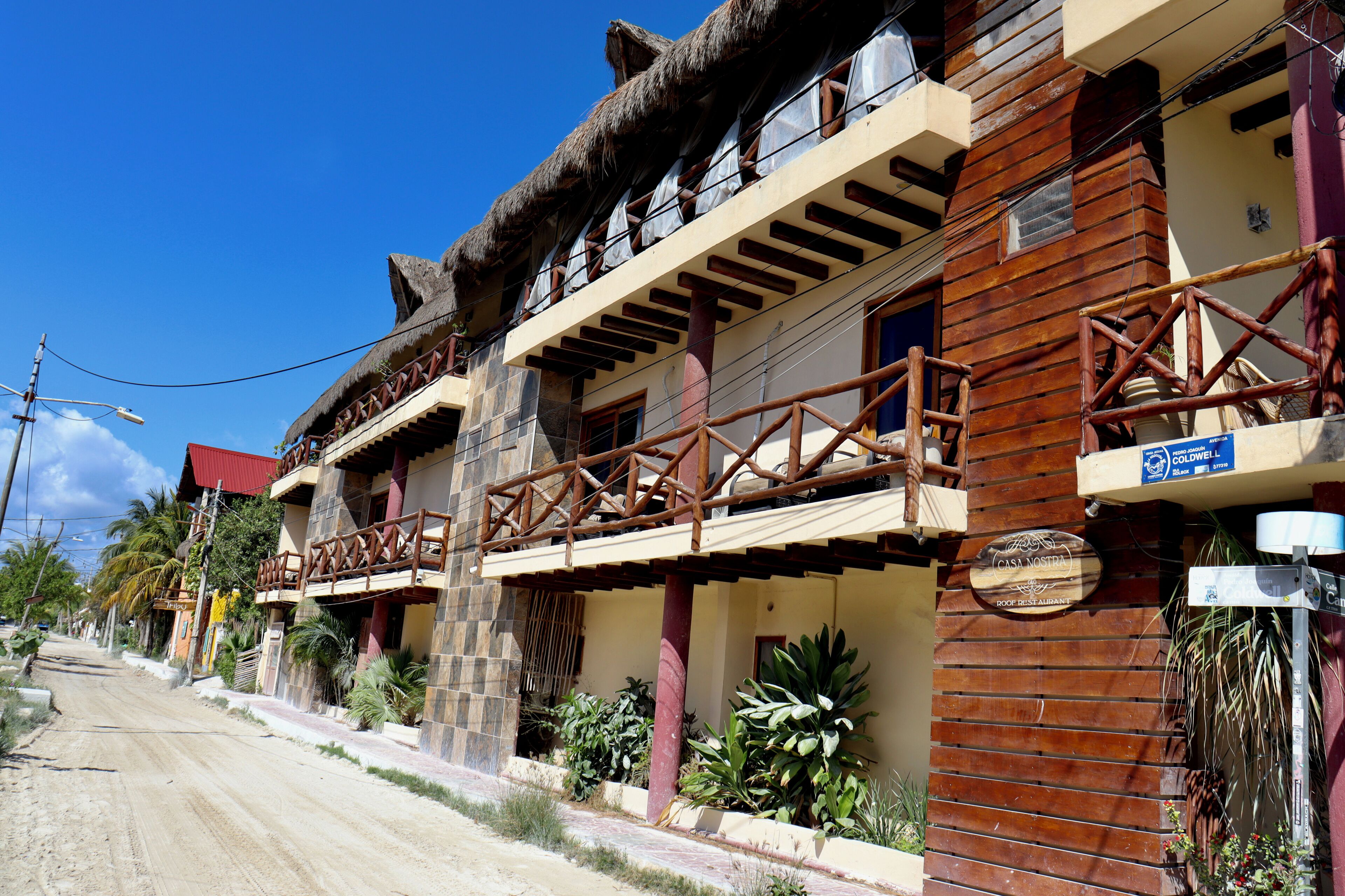 Um edifício com fachada de madeira, varandas e uma placa indicando um restaurante.