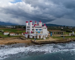 Um edifício semelhante a um castelo, com várias torres, localizado perto de um corpo d'água.