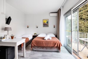 Quarto com cama, escrivaninha, cadeira, janela e varanda.