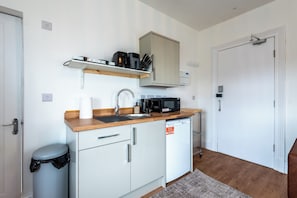 Quarto Clássico, vista parcial para o mar | Cozinha privada | Um frigorífico, um micro-ondas, utensílios de cozinha 