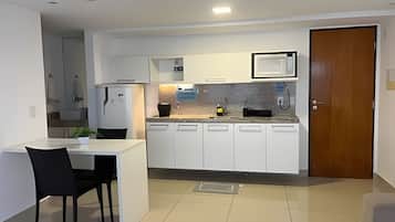 Um frigorífico, um micro-ondas, uma placa de cozinha