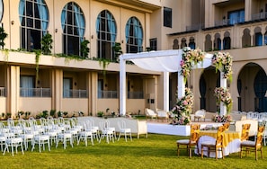 Espaço para eventos ao ar livre, com palco, cadeiras e uma tenda branca.