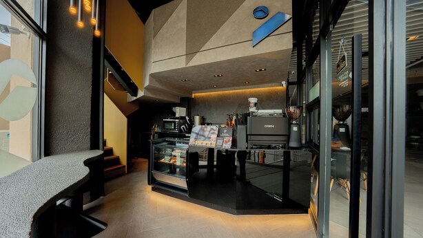 Um interior moderno com balcão, área de estar e máquina de café.