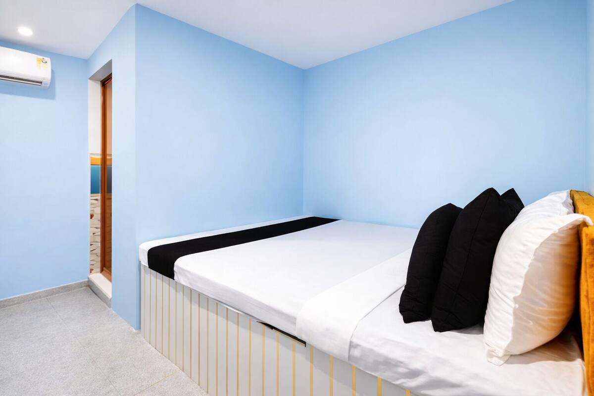Um quarto com cama, almofadas e radiador.