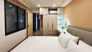 Quarto de hotel com cama, penteadeira com espelho e guarda-roupa.
