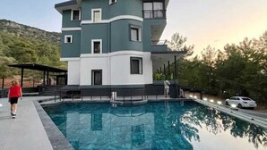 Um edifício moderno de vários andares com piscina em frente.